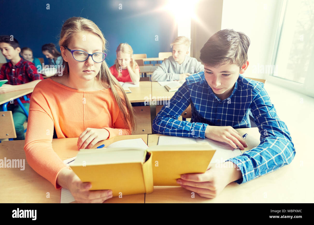 Teen students reading book desk hi-res stock photography and images - Alamy