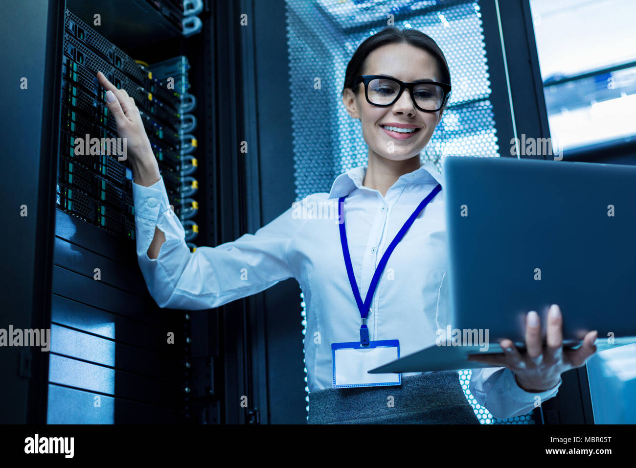 Joyful operator working in a server cabinet Stock Photo - Alamy