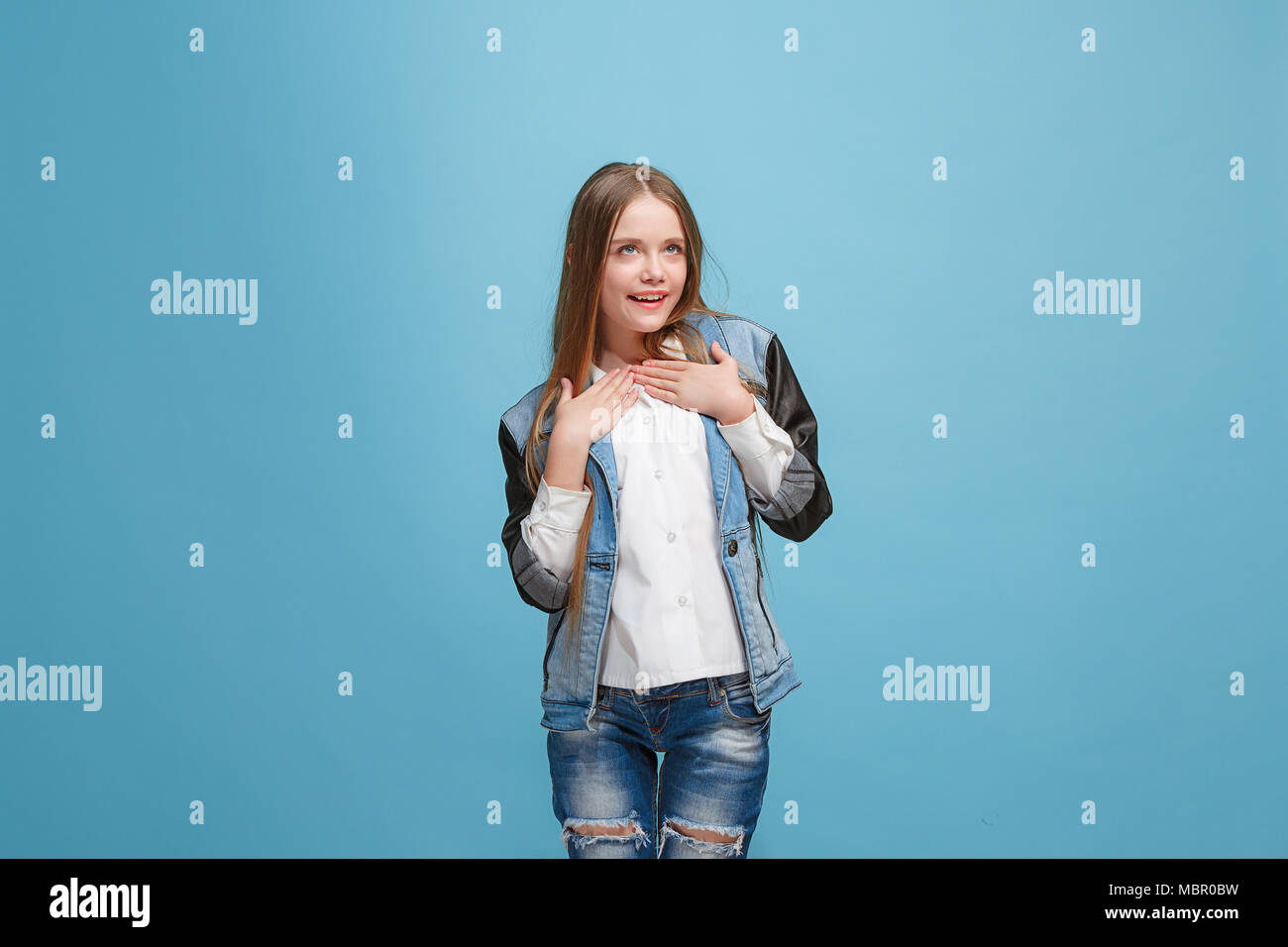 The happy teen girl standing and smiling against pink background Stock ...