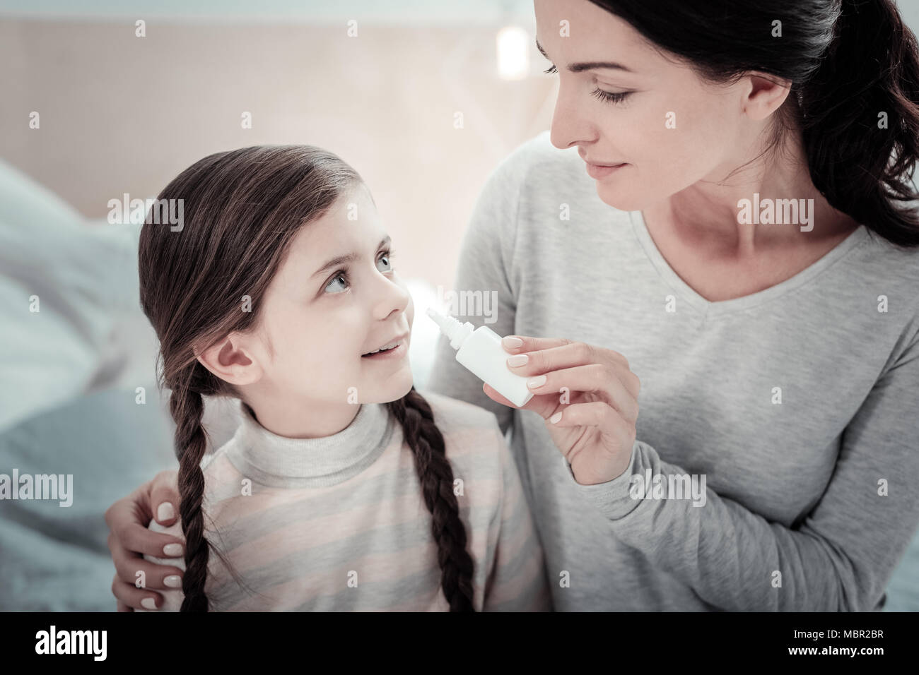 Pleasant cute girl smiling and looking at her mother Stock Photo - Alamy