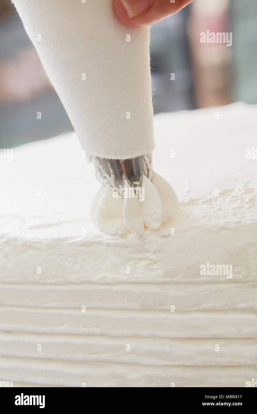 Woman Icing Cake in Commercial Kitchen Stock Photo - Alamy