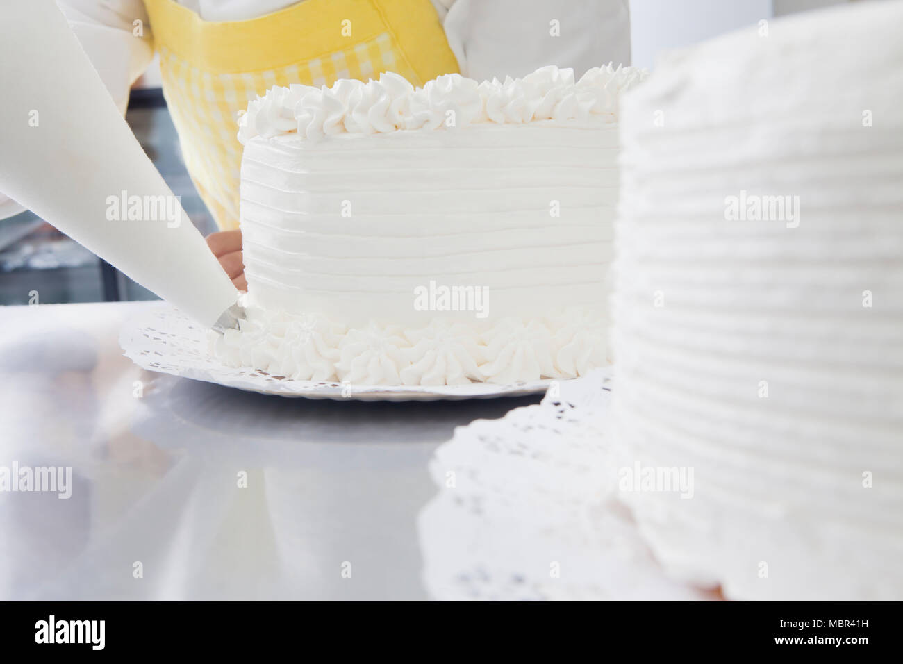 Woman Icing Cake in Commercial Kitchen Stock Photo - Alamy