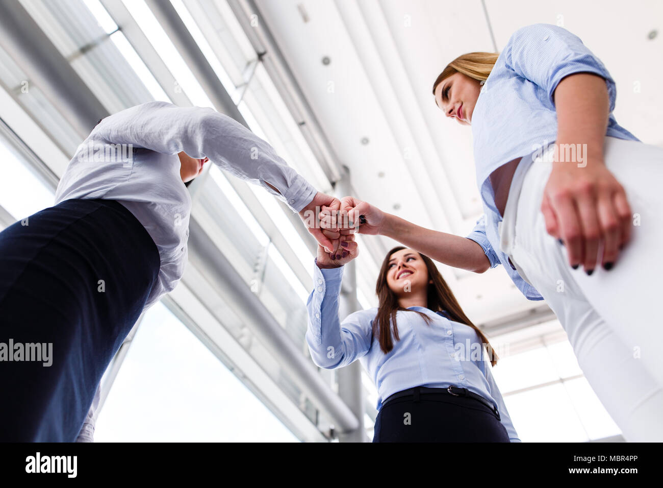 Three successful women celebrate their success by getting their hands ...