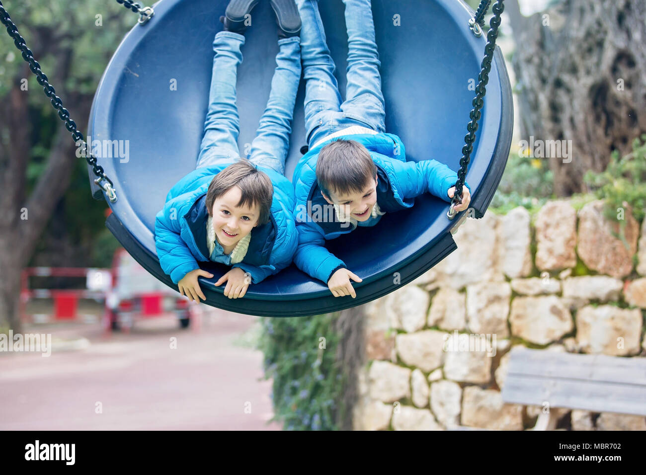 Two preschool children in a swing, having fun springtime Stock Photo ...