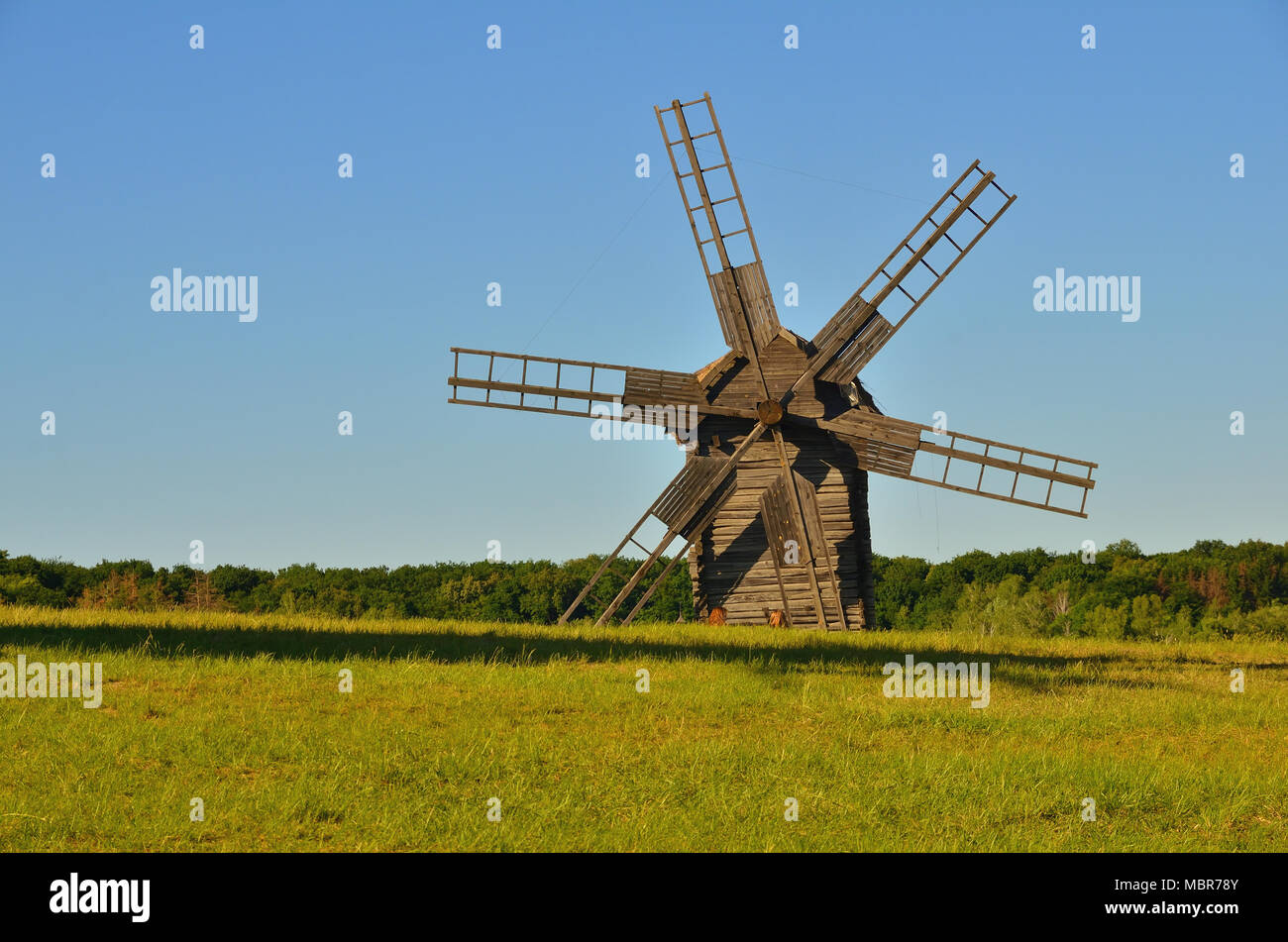 Large wooden windmill in a green field under the sunlight Stock Photo ...