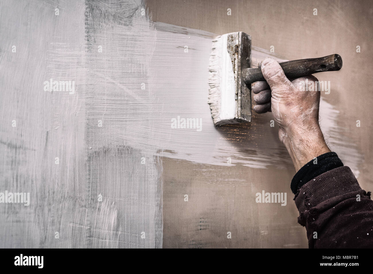 Decorator prime a putty wall before applying a decorative layer of ...