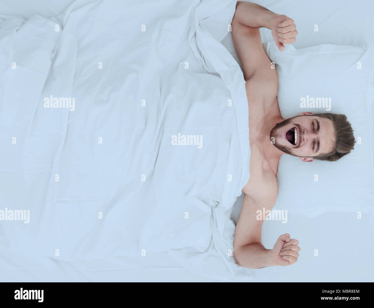 top view. happy man waking up in a comfortable bed Stock Photo - Alamy