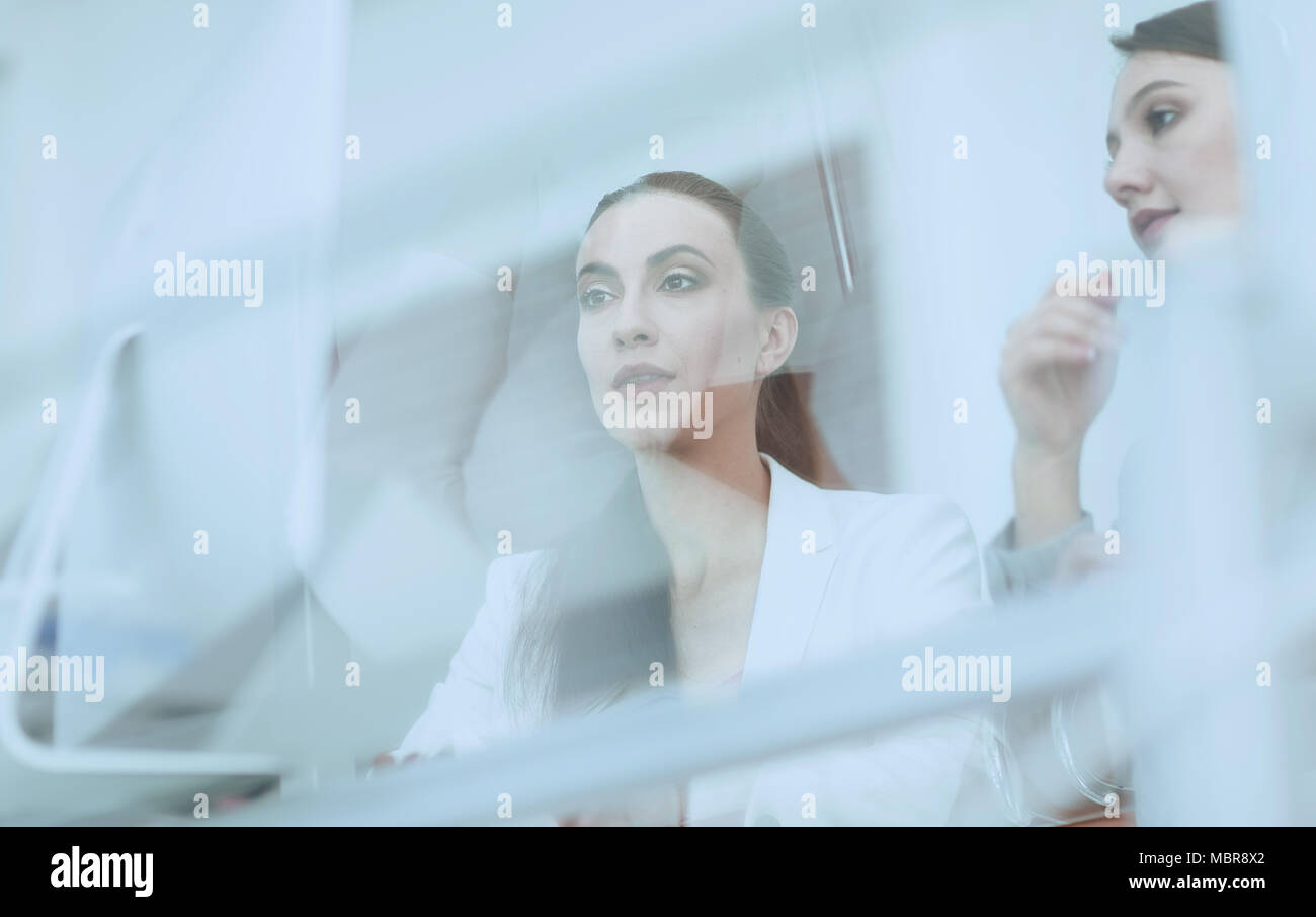 behind the glass.business team sitting at Desk Stock Photo - Alamy