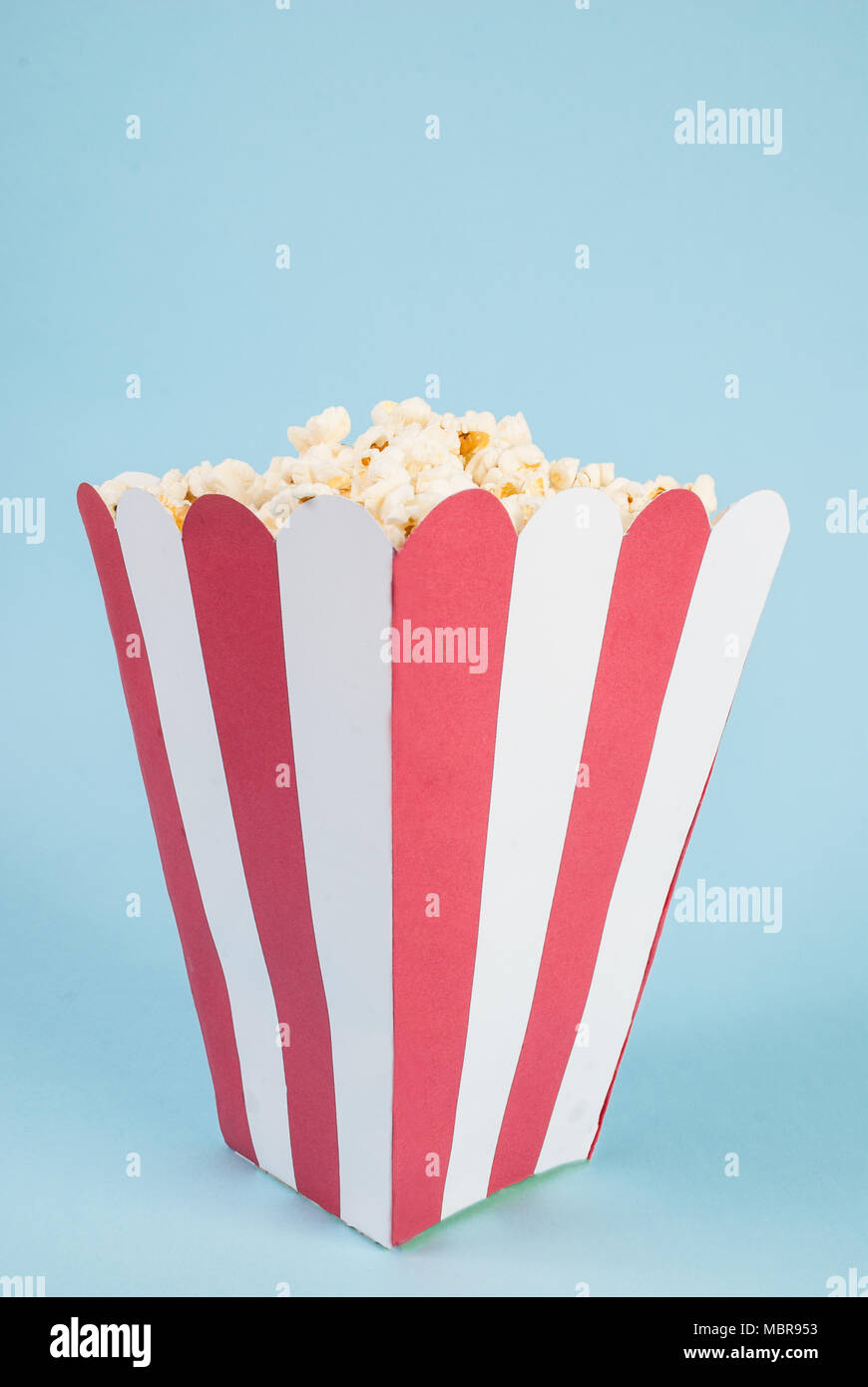 Red white box with popcorn on blue background Stock Photo - Alamy