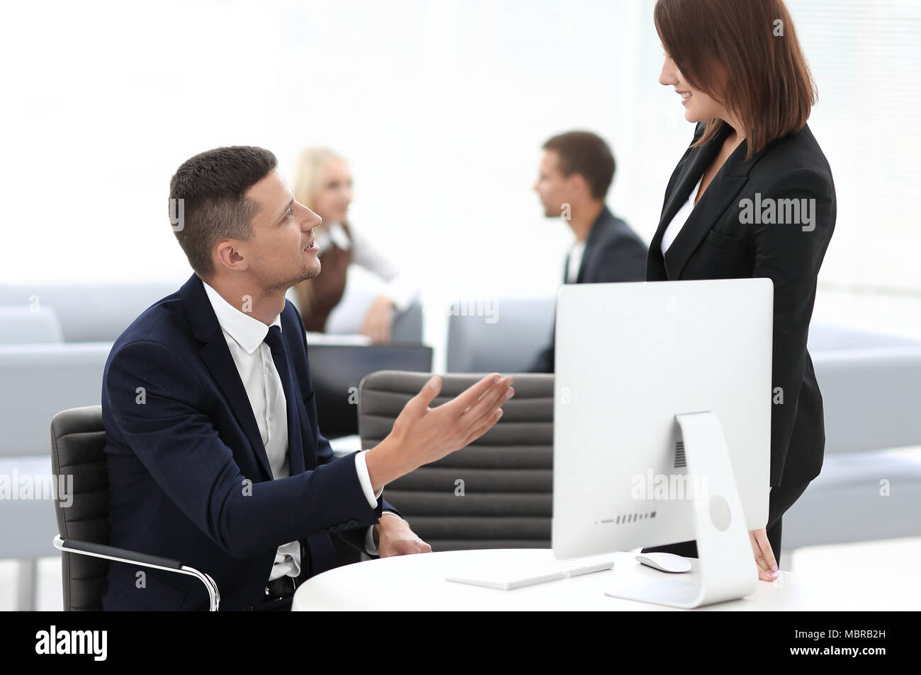 employees sitting behind a Desk in the office Stock Photo - Alamy