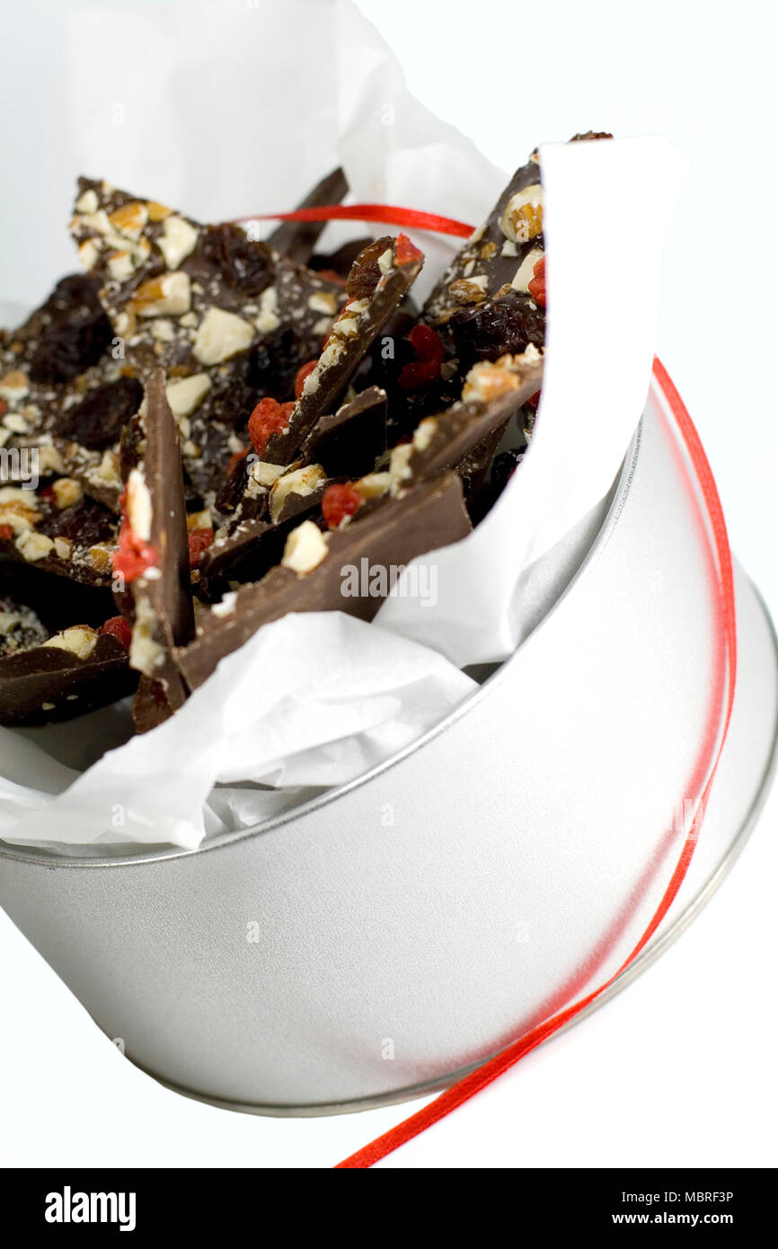 metal box full of chocolate slices and red ribbon isolated on white ...