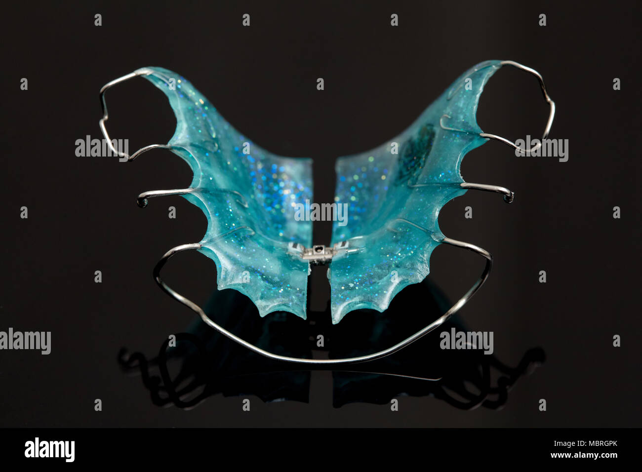 Colorful dental braces or retainers for teeth on black glass background ...