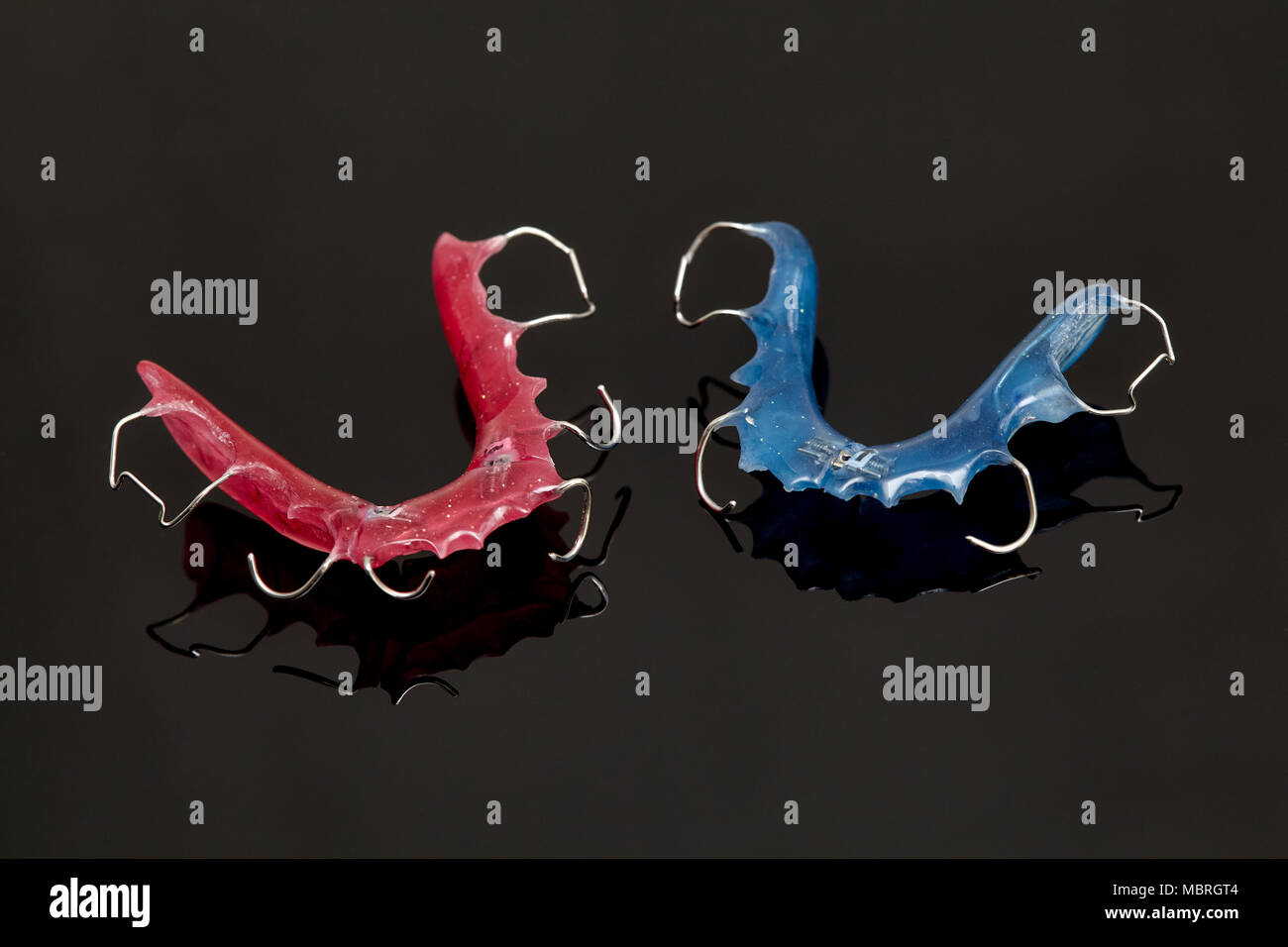 Colorful dental braces or retainers for teeth on black glass background ...