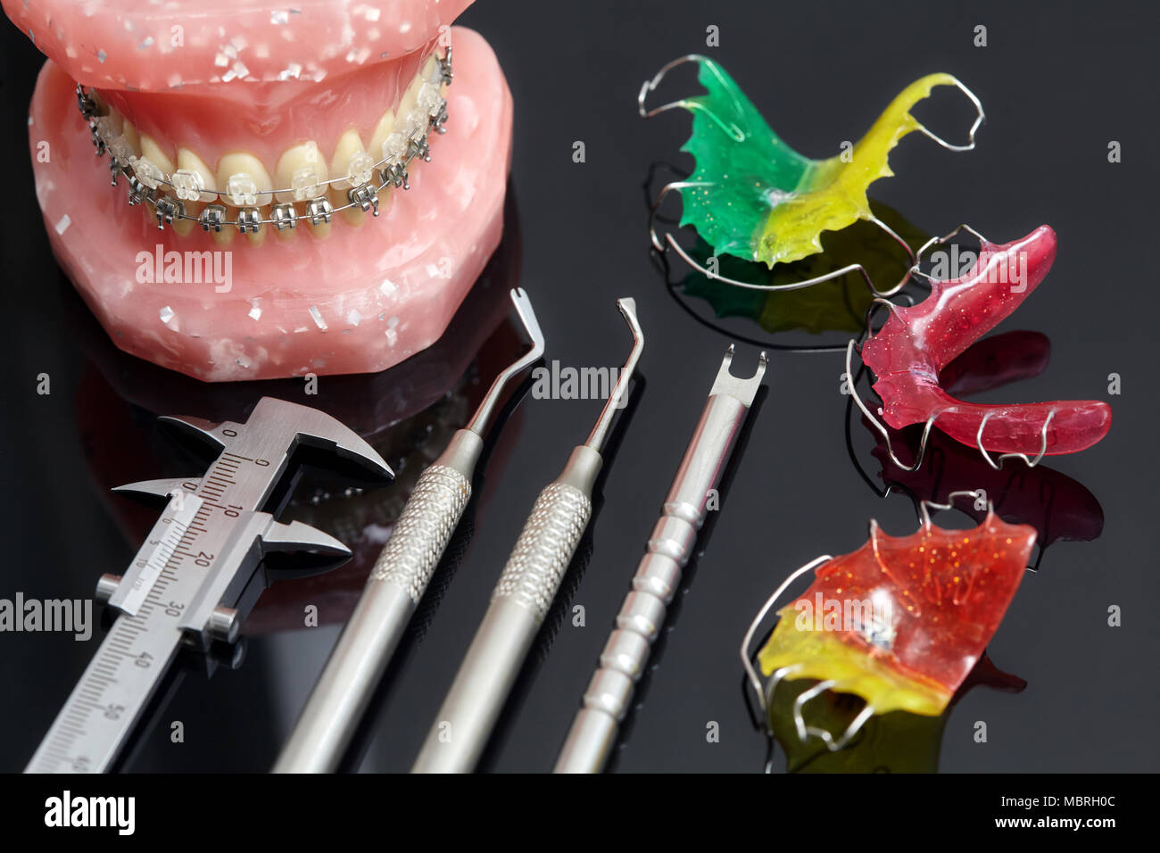 Human jaw or teeth model with dental braces and dentist tools and ...