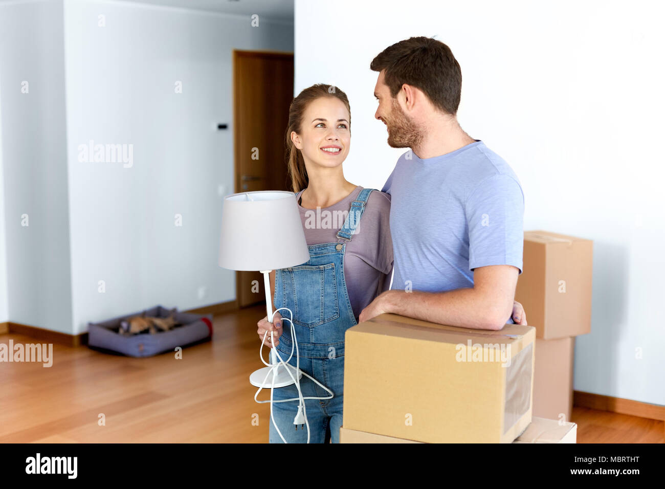 couple with boxes and lamp moving to new home Stock Photo - Alamy