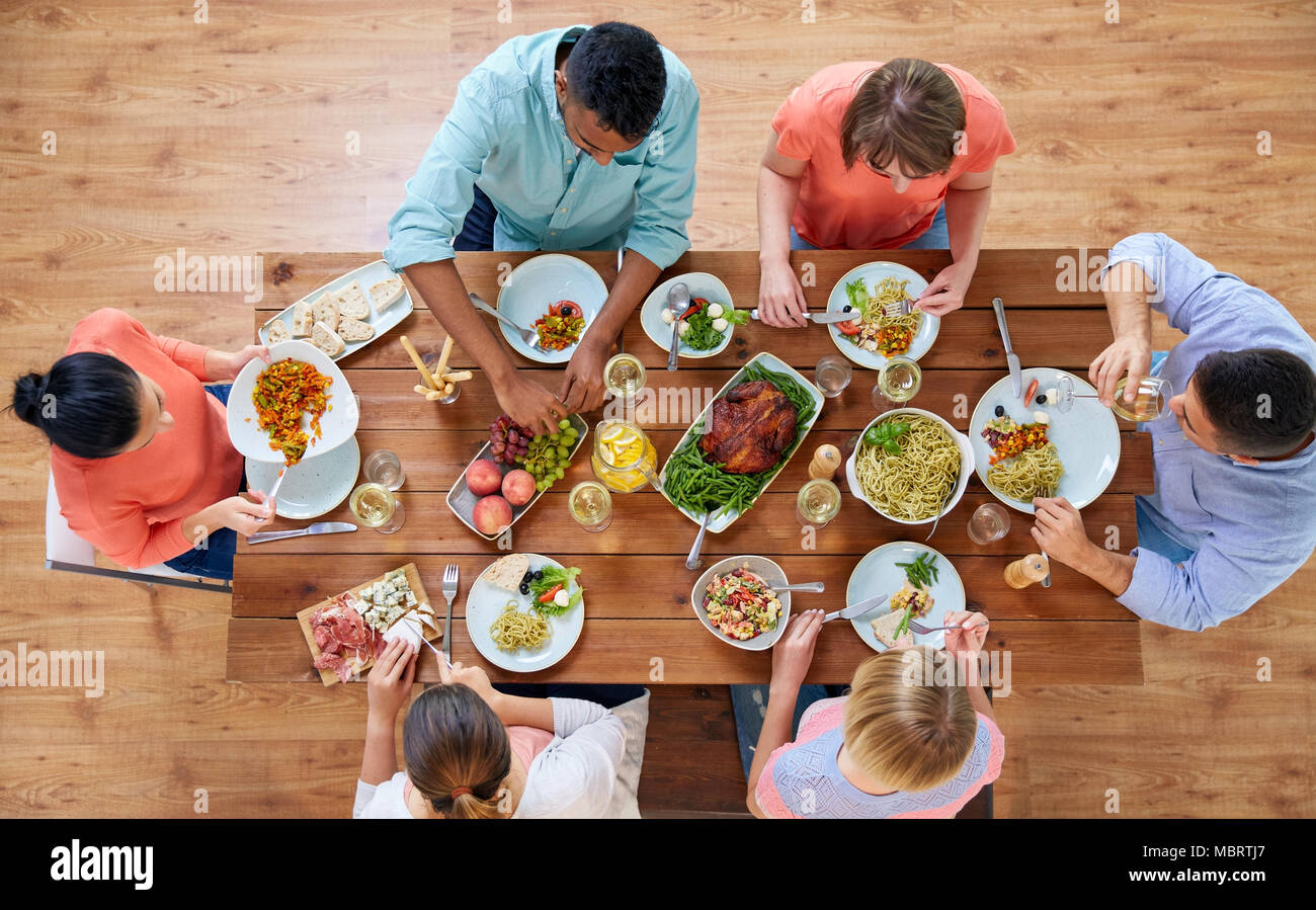 group of people eating at table with food Stock Photo - Alamy