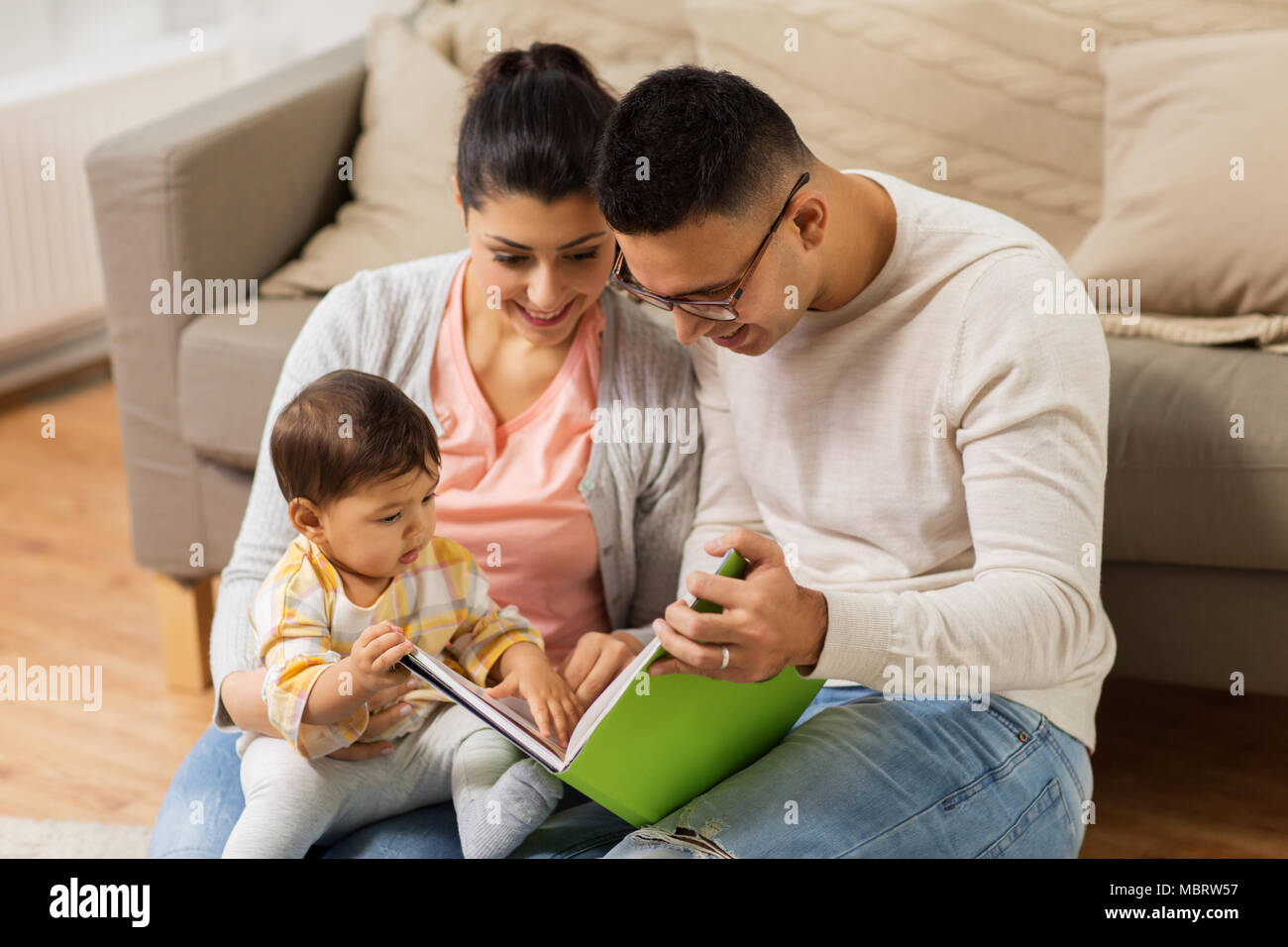 happy family with baby reading book at home Stock Photo - Alamy