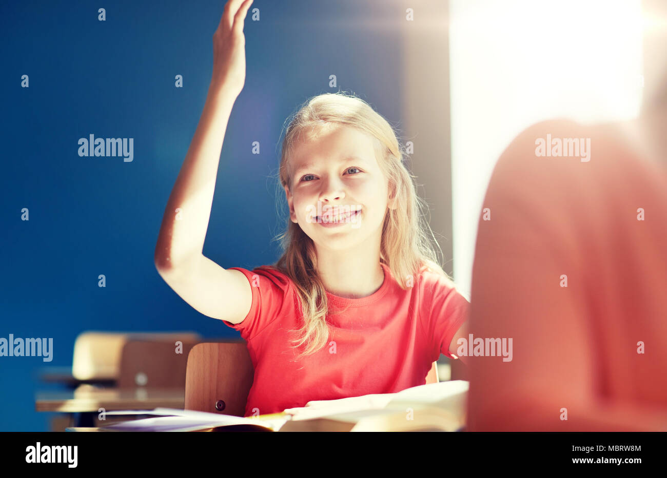 happy student girl raising hand at school lesson Stock Photo - Alamy