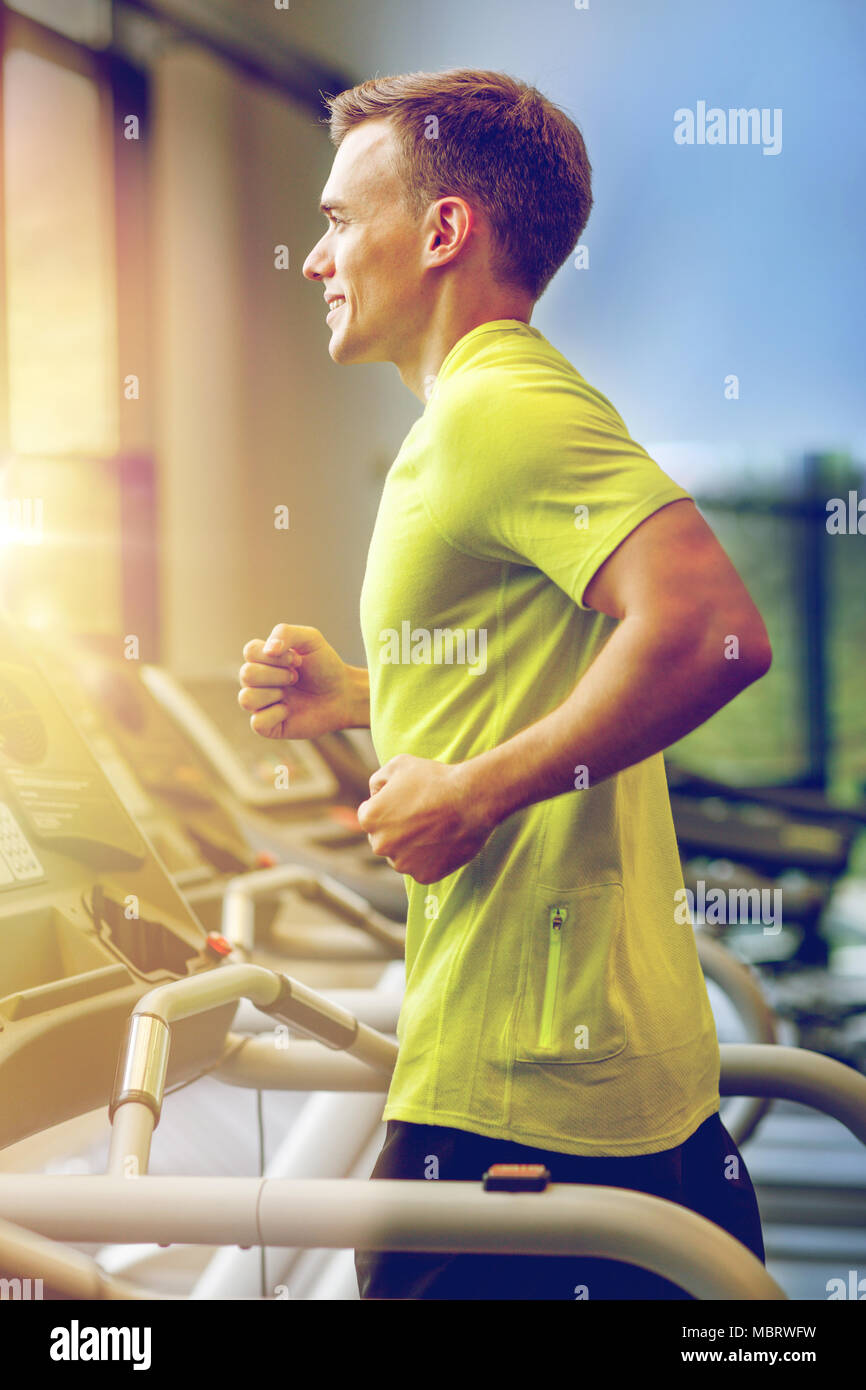 smiling man exercising on treadmill in gym Stock Photo - Alamy