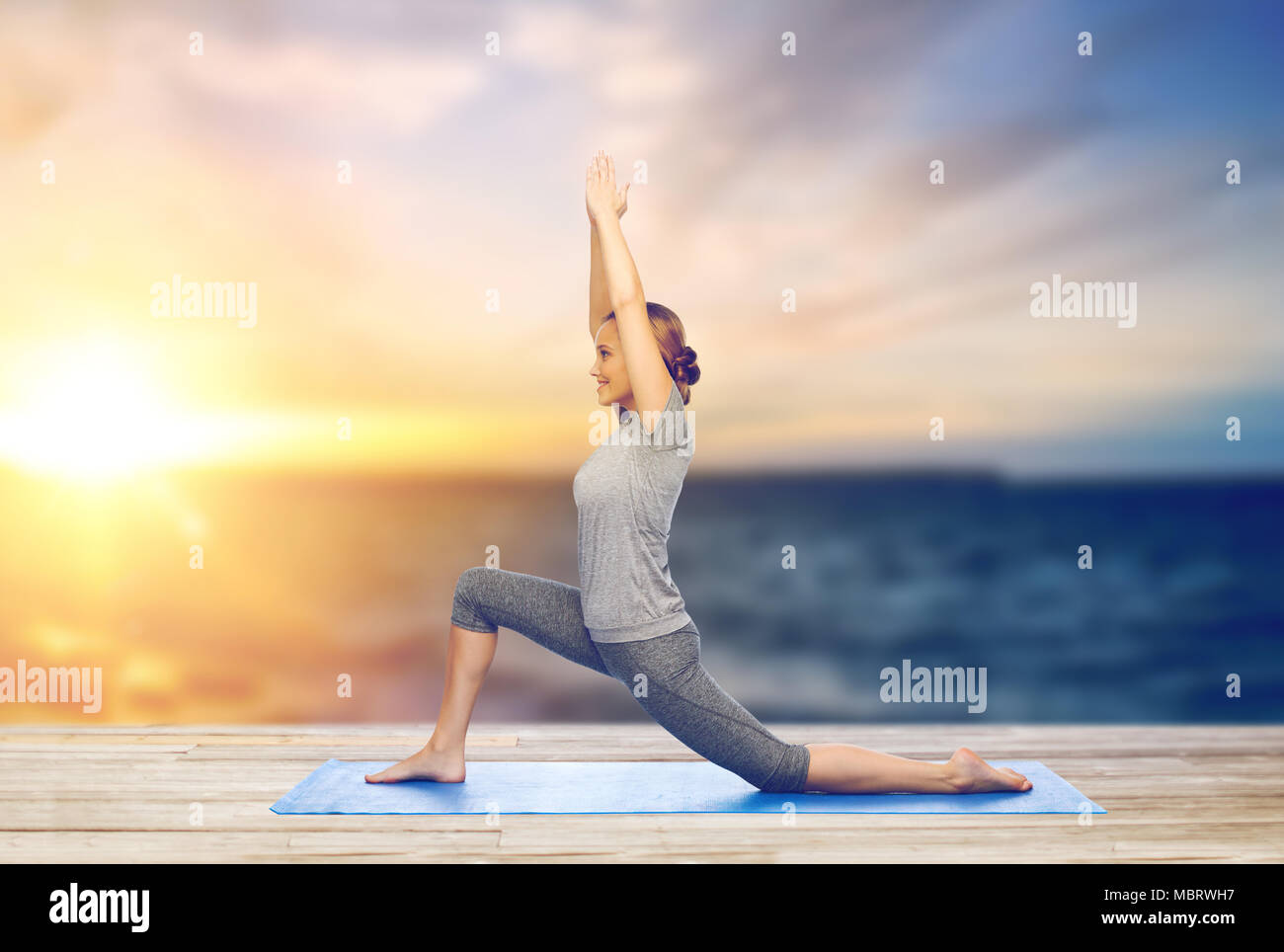 happy woman making yoga in low lunge on mat Stock Photo - Alamy