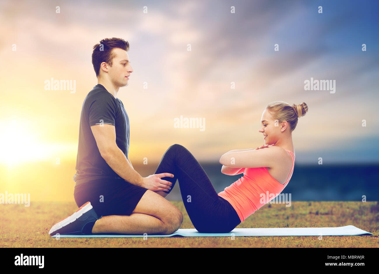 happy sportive couple doing sit-ups outdoor Stock Photo - Alamy