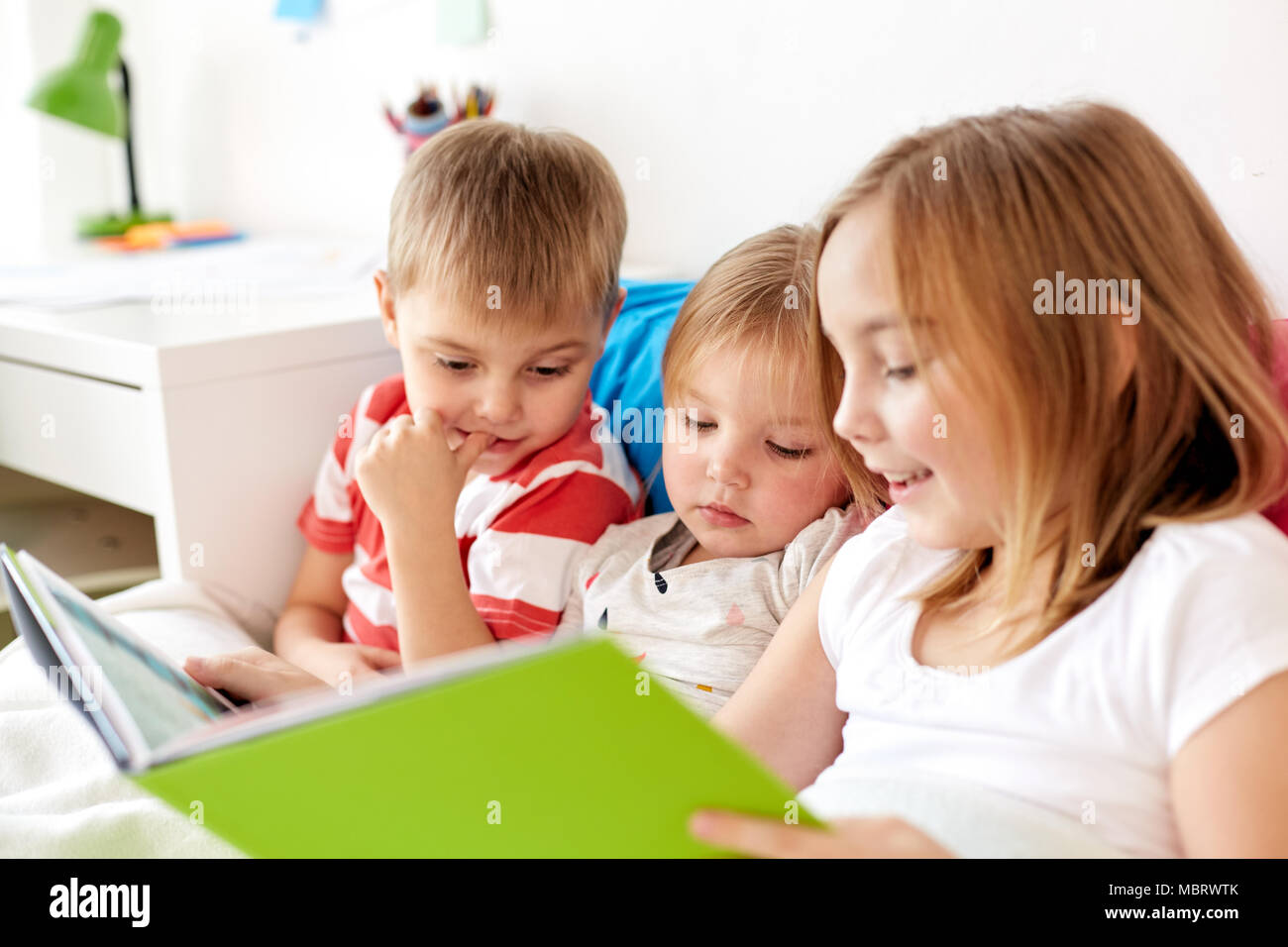little kids reading book in bed at home Stock Photo - Alamy