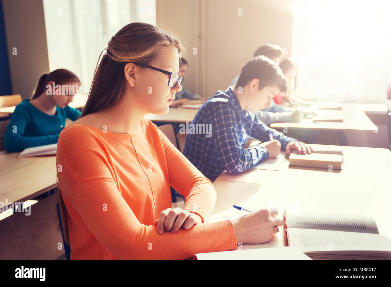 group of students with books writing school test Stock Photo - Alamy