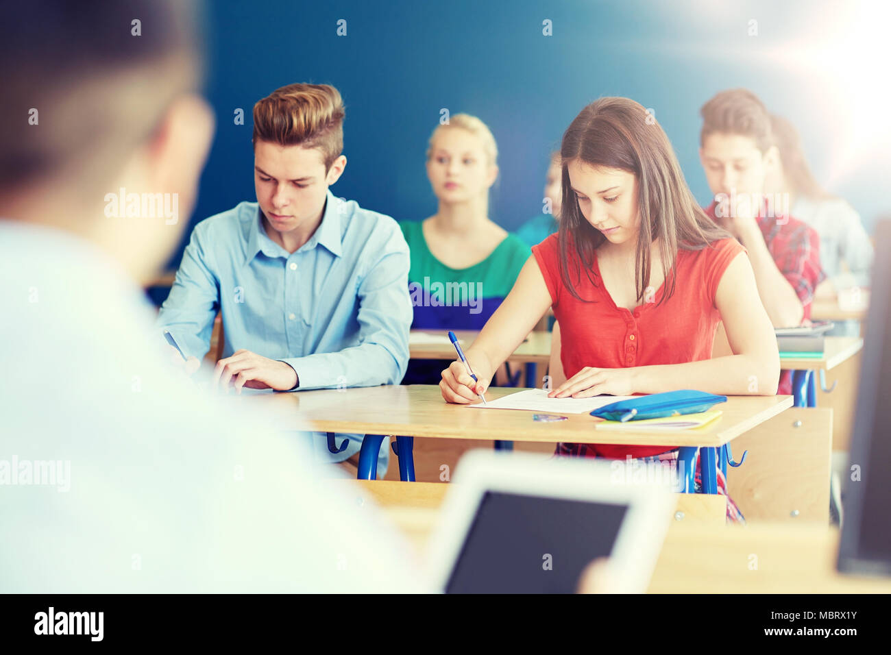 group of students with books writing school test Stock Photo - Alamy