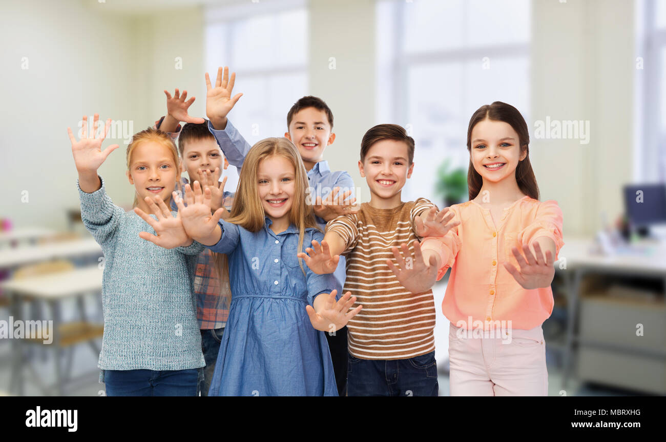 happy students waving hands at school Stock Photo - Alamy