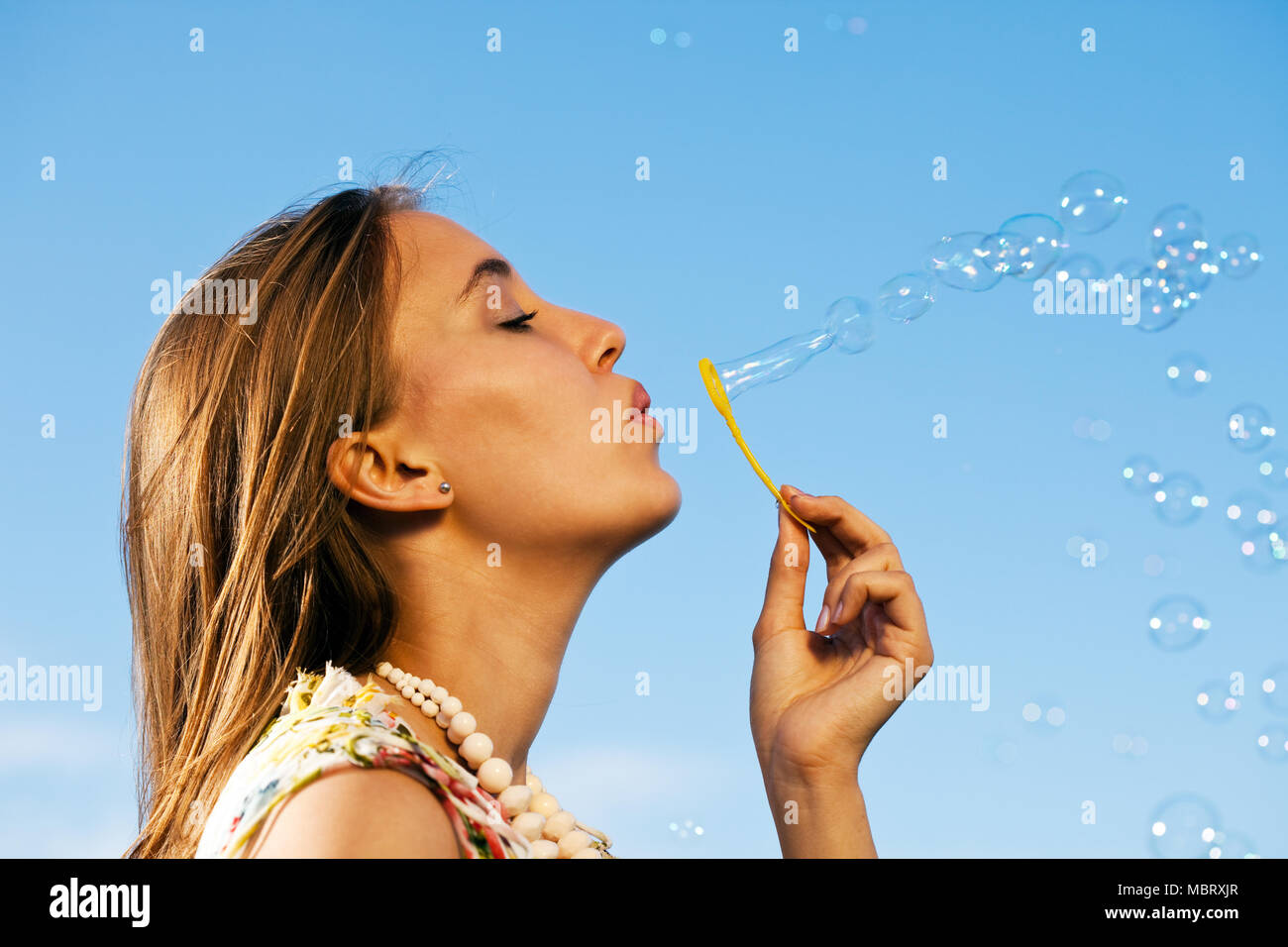 Woman blowing bubbles Stock Photo - Alamy