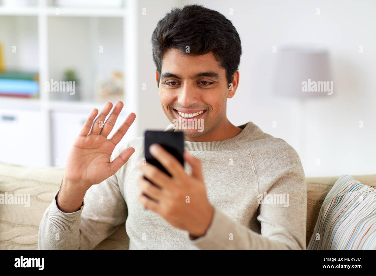 happy man having video call on smartphone at home Stock Photo - Alamy