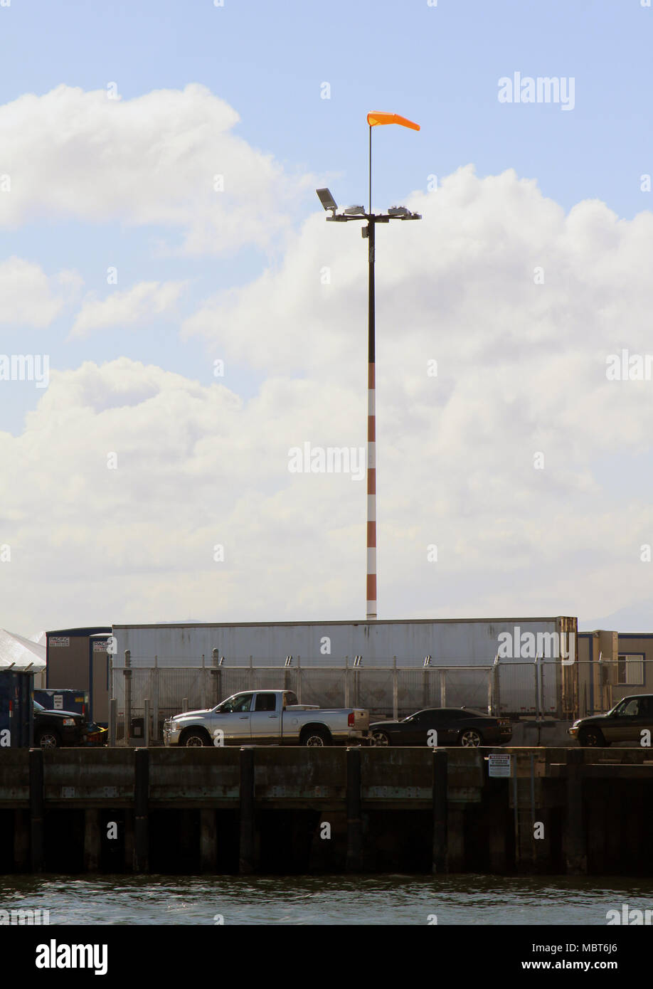 Light pole with a wind sock on top and the Smith Cove waterway ship ...