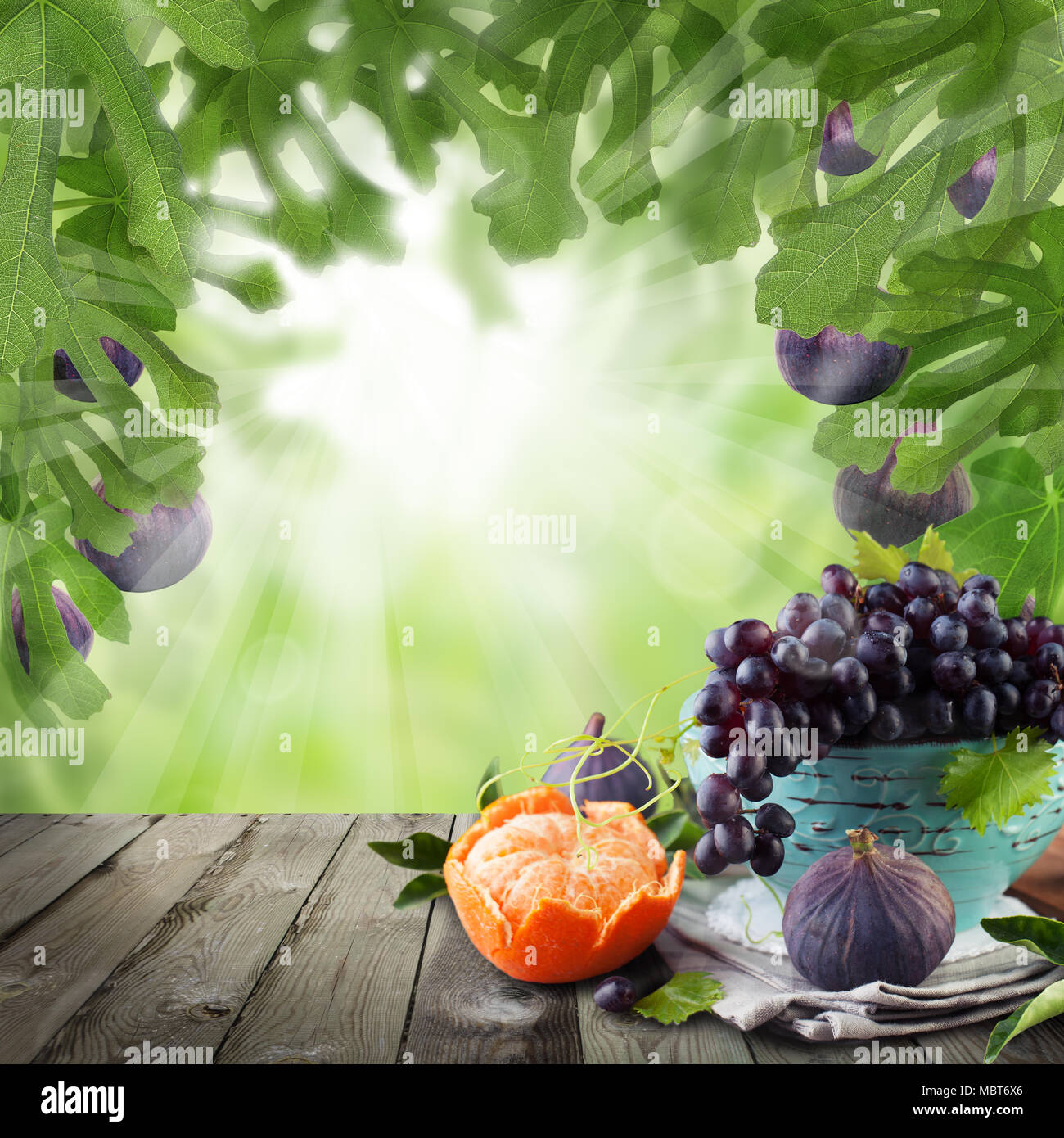 Mandarin, figs and grapes fruits on abstract green bokeh background ...