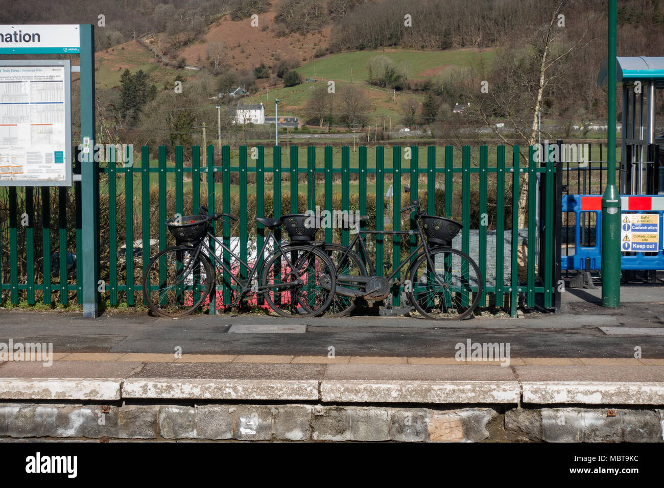 Vintage bikes chained to railing atr Machynlleth Railway Station. Powys ...