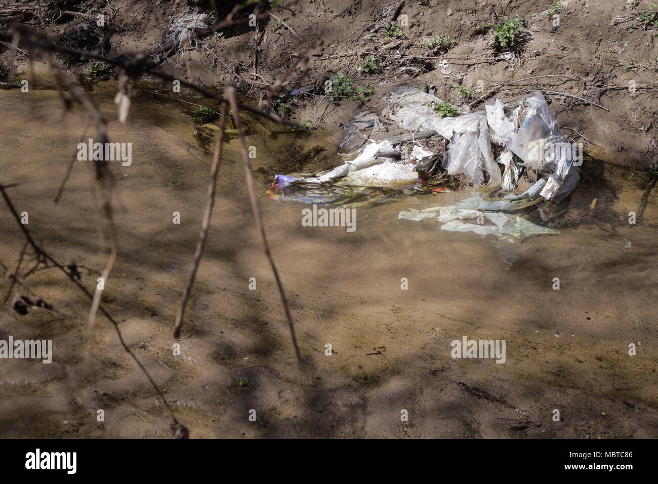 Heavy polluted water stream with domestic garbage Stock Photo - Alamy