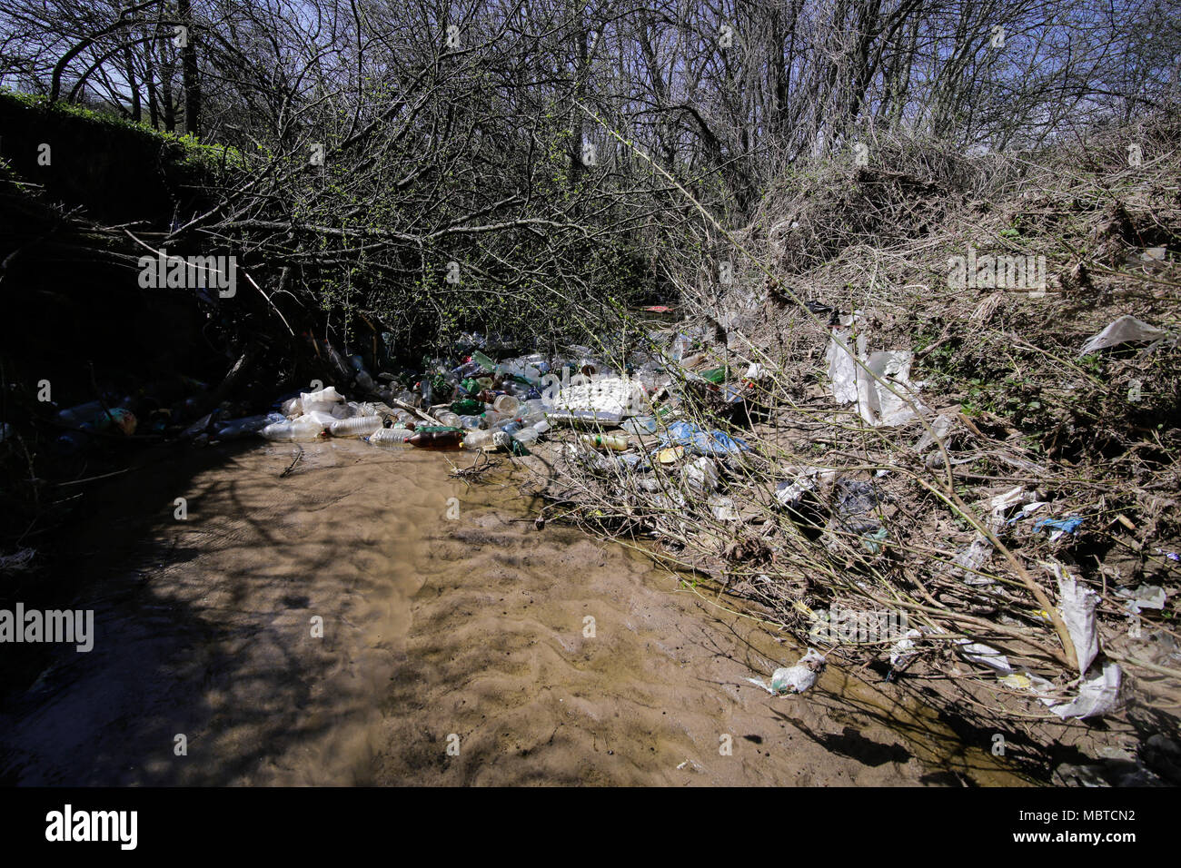 Heavy polluted water stream with domestic garbage Stock Photo - Alamy