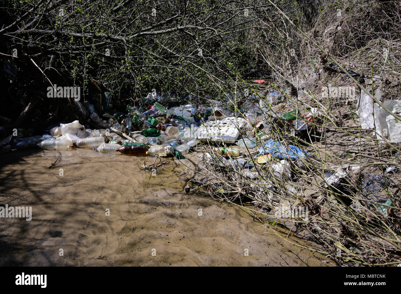 Heavy polluted water stream with domestic garbage Stock Photo - Alamy