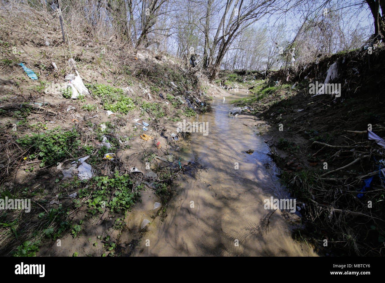 Heavy polluted water stream with domestic garbage Stock Photo - Alamy