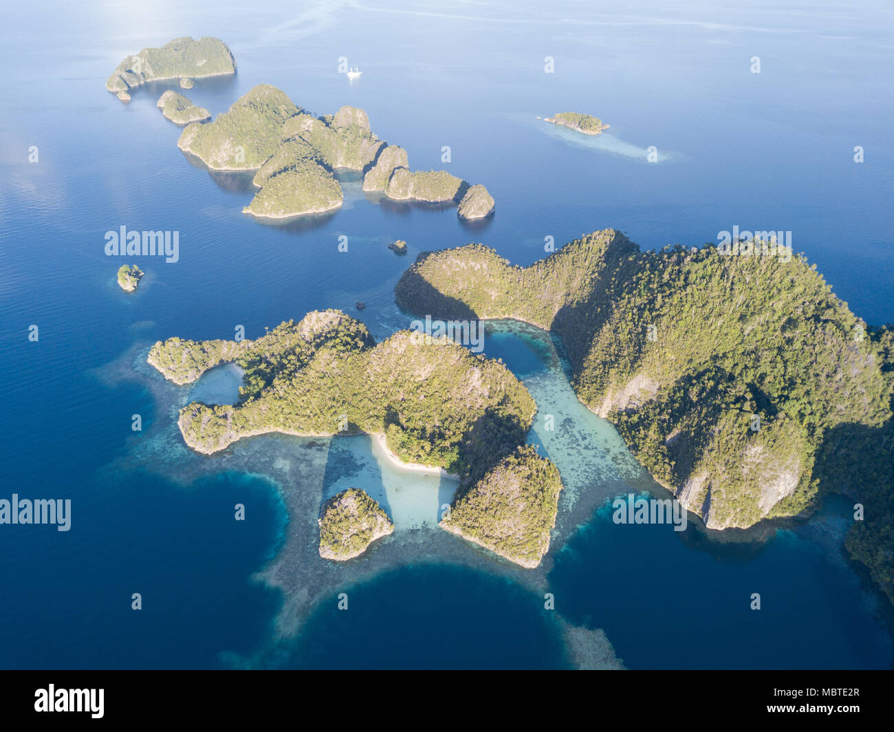 Amazing limestone islands rise from the calm seascape around Misool ...