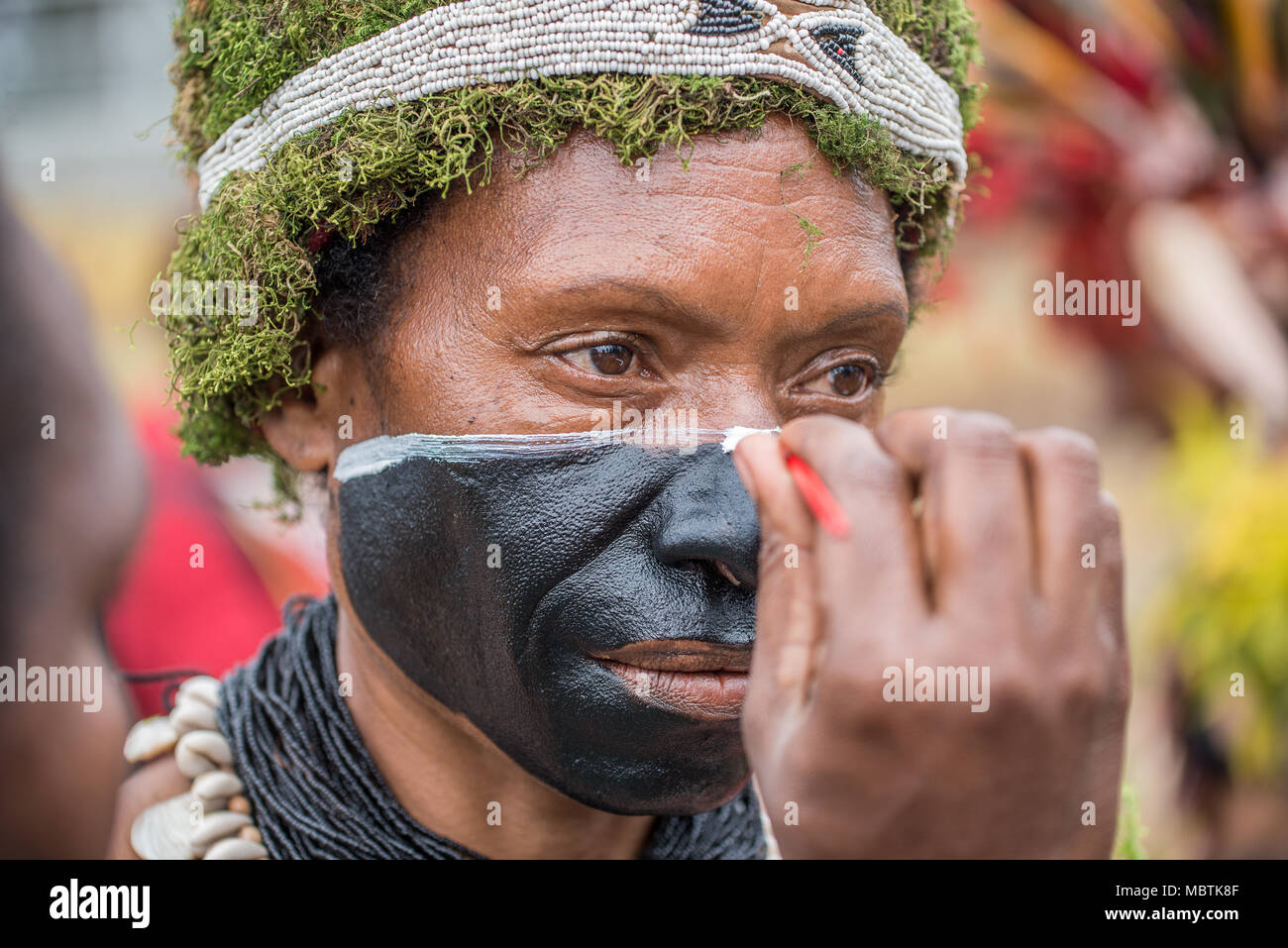 A tribal woman having her face painted for the Mount Hagen Cultural ...