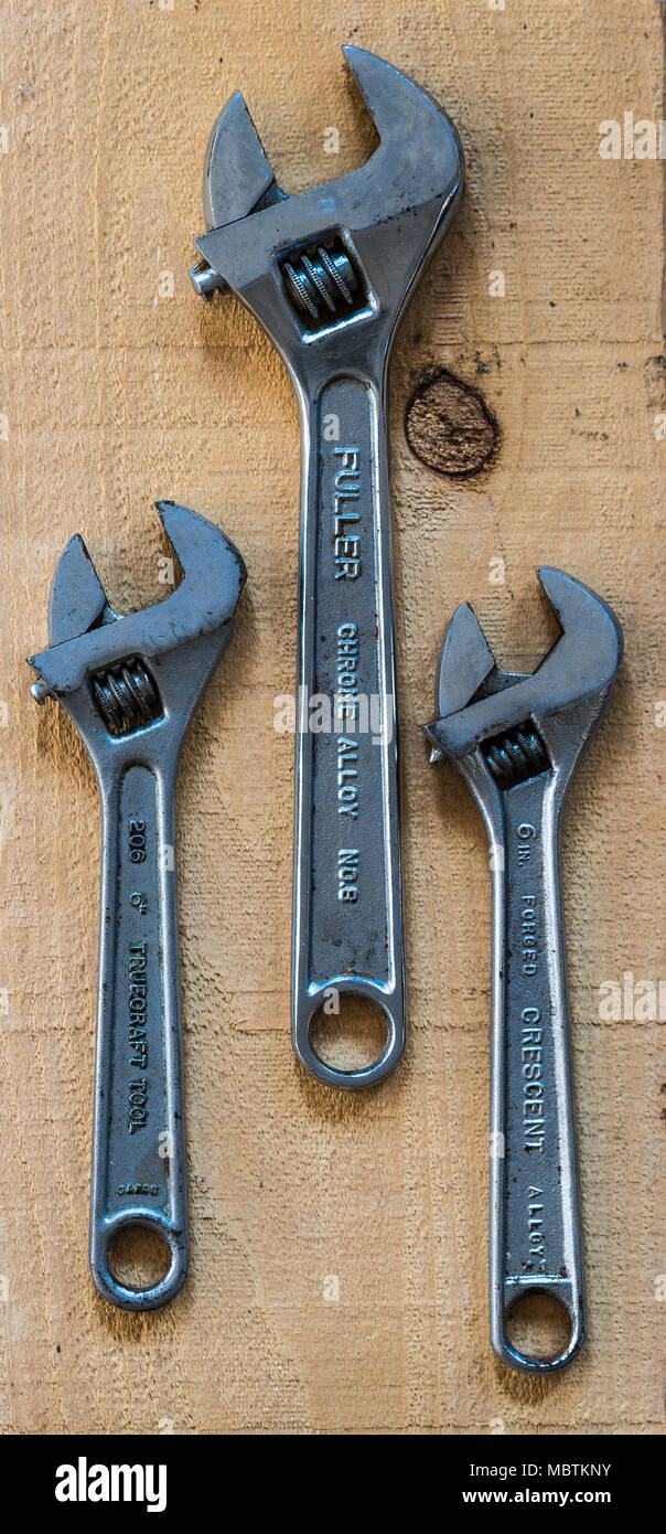 three crescent wrench tools on wooden board Stock Photo - Alamy