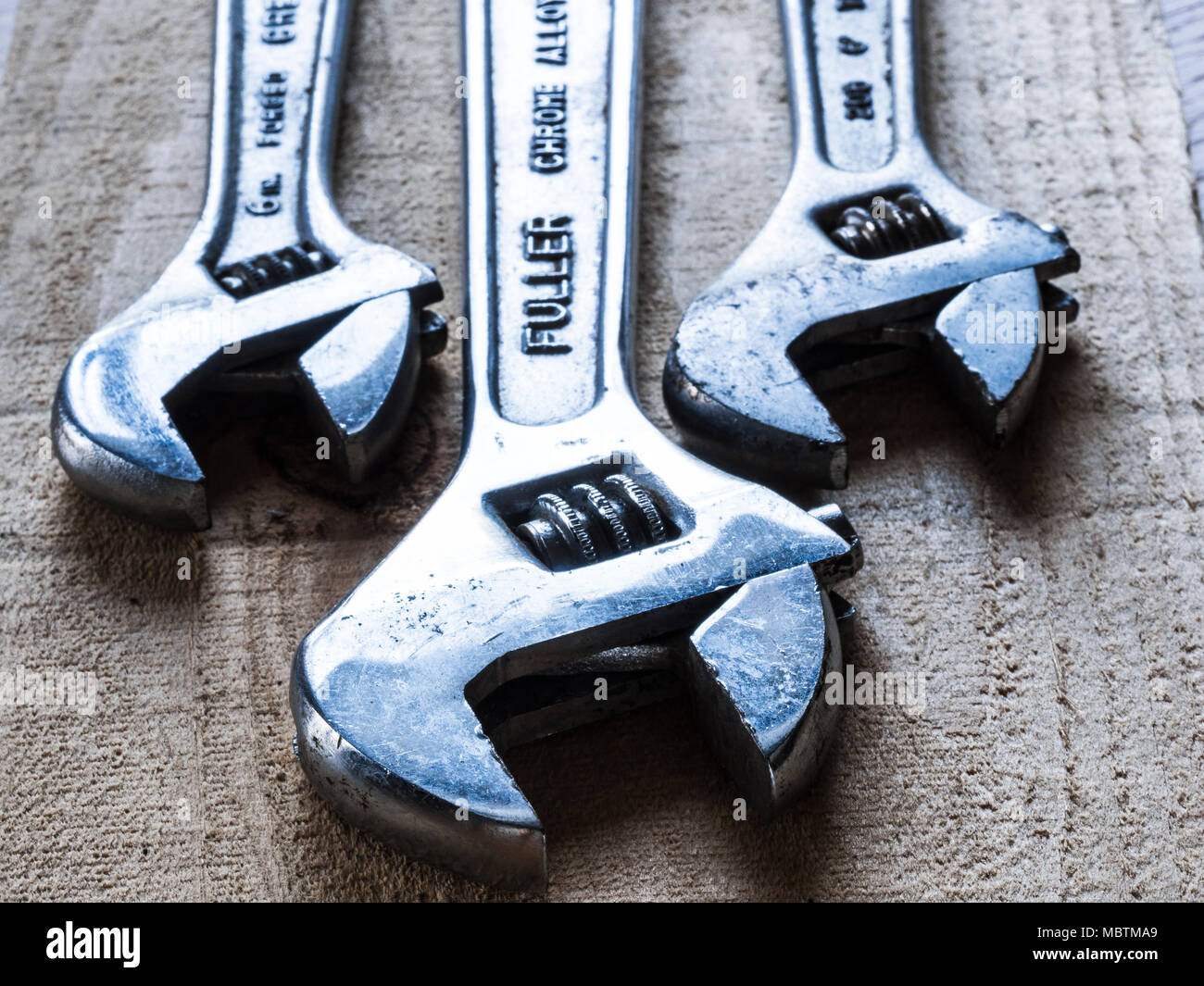 three crescent wrench tools on wooden board Stock Photo - Alamy