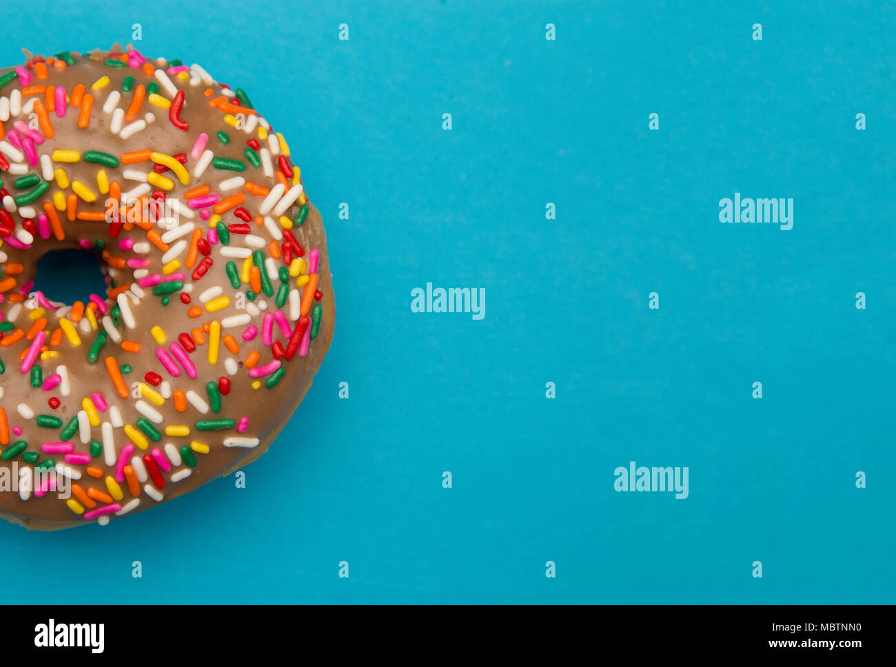 Maple Flavored Sprinkle Donut on a Blue Background Stock Photo - Alamy