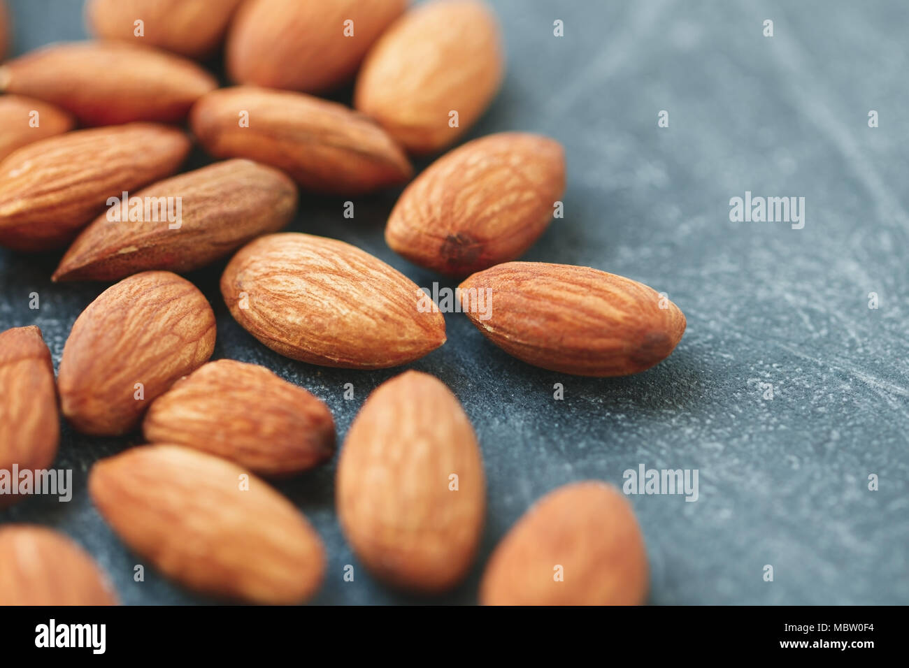 Macro photography of almond nuts over grey background. The concept of ...