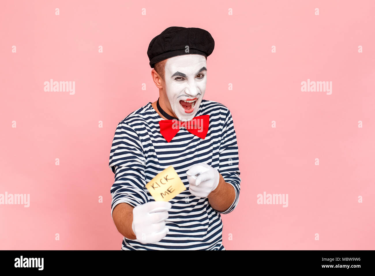 Handsome man holding sticker, laugh and pointing finger at camera ...