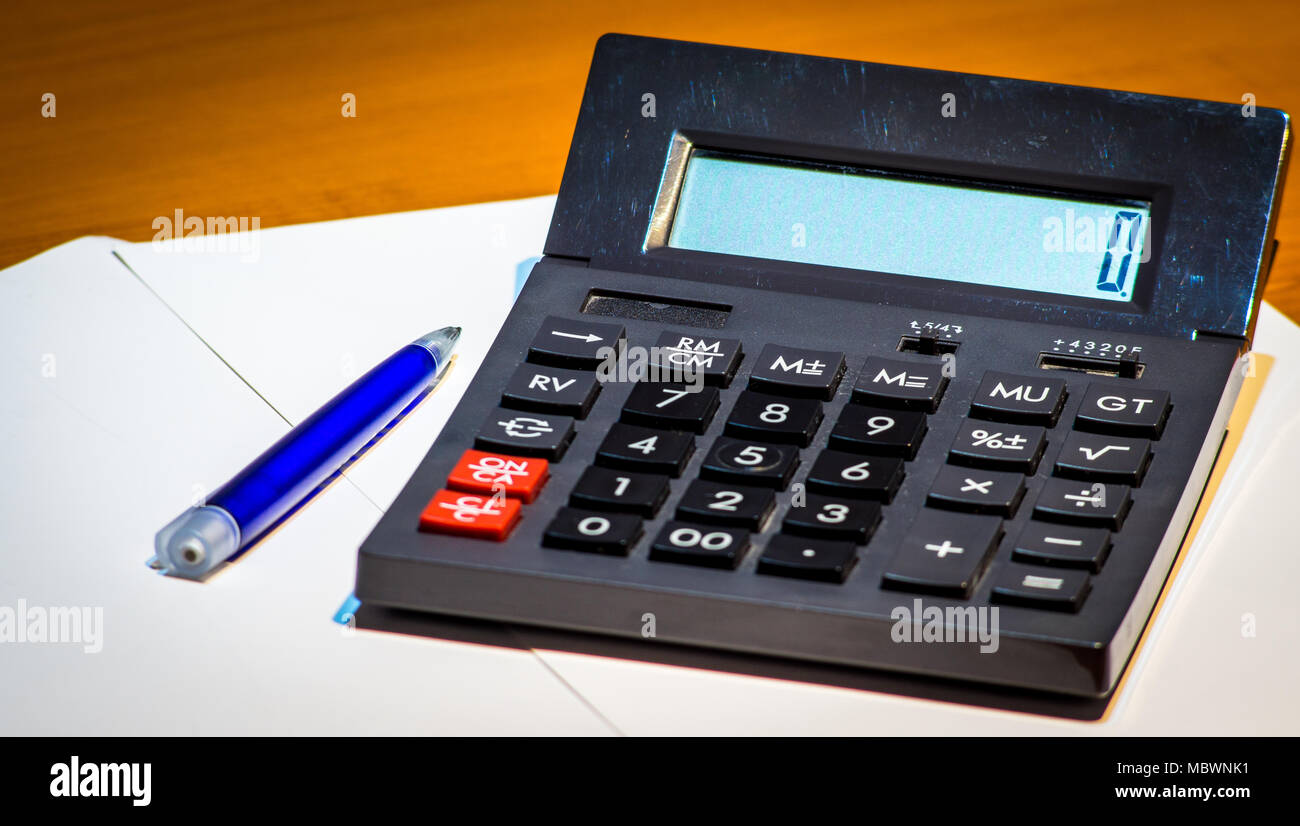 Black calculator with 0 on display and a pen Stock Photo - Alamy