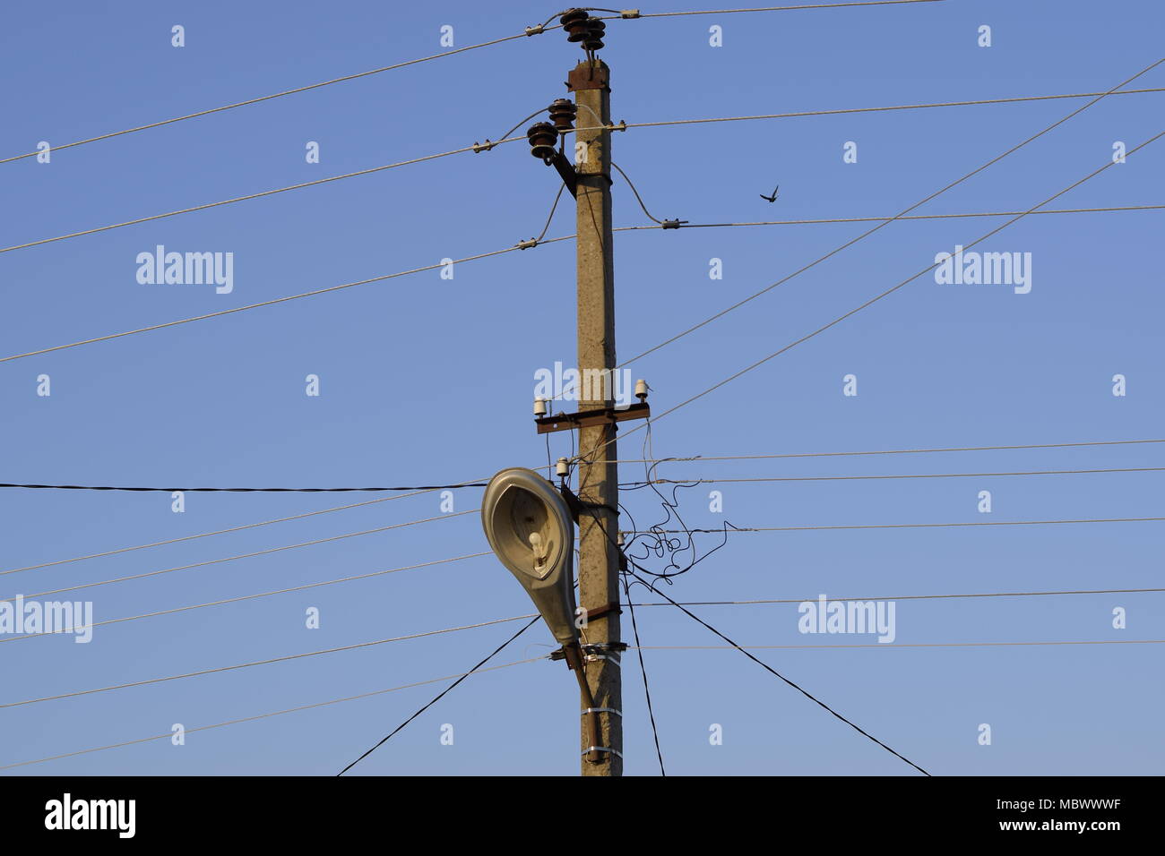 power line post with a street lighting lamp. blue sky Stock Photo - Alamy