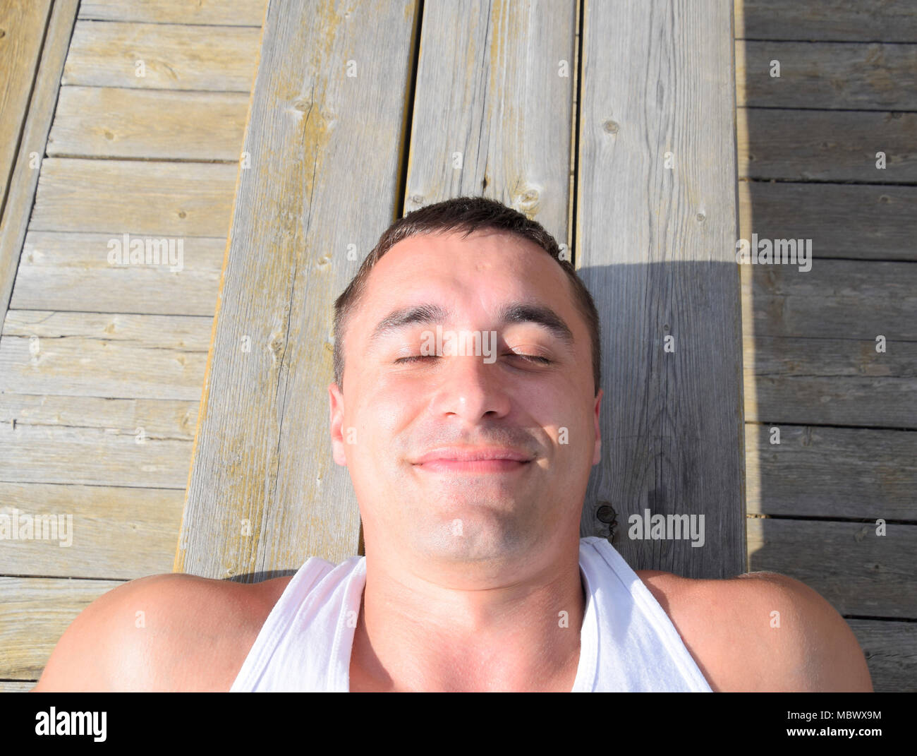 man is lying on a bench and stretching. A smile on the face of a man ...
