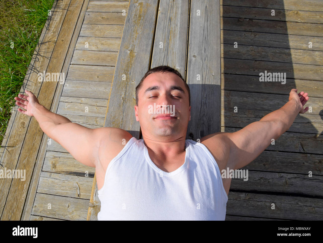 man is lying on a bench and stretching. A smile on the face of a man ...