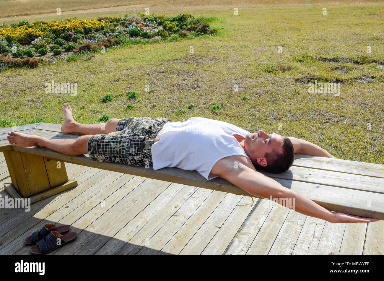 man is lying on a bench and stretching. A smile on the face of a man ...